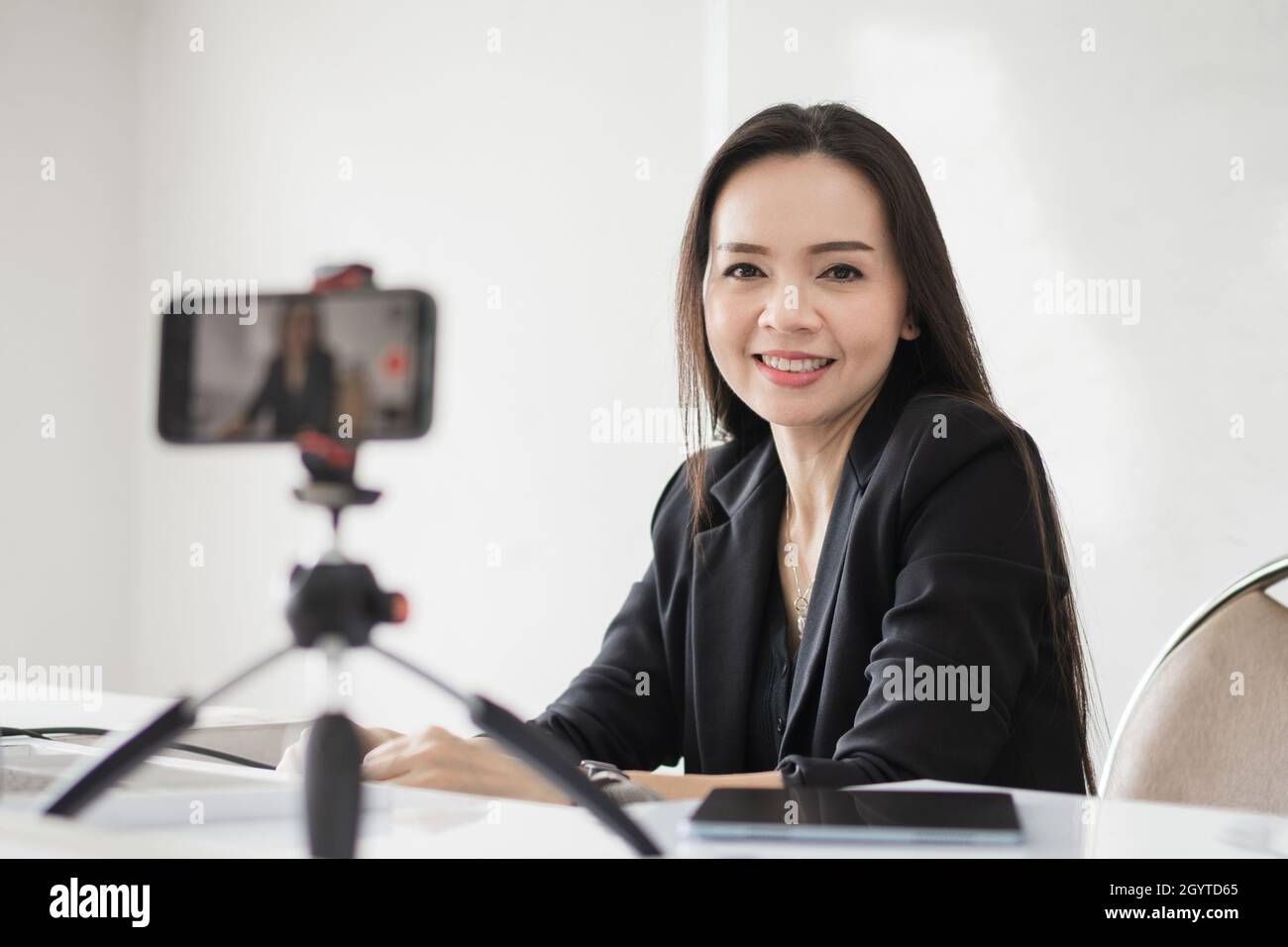 Asian female tutor recording an online lesson Stock Photo - Alamy