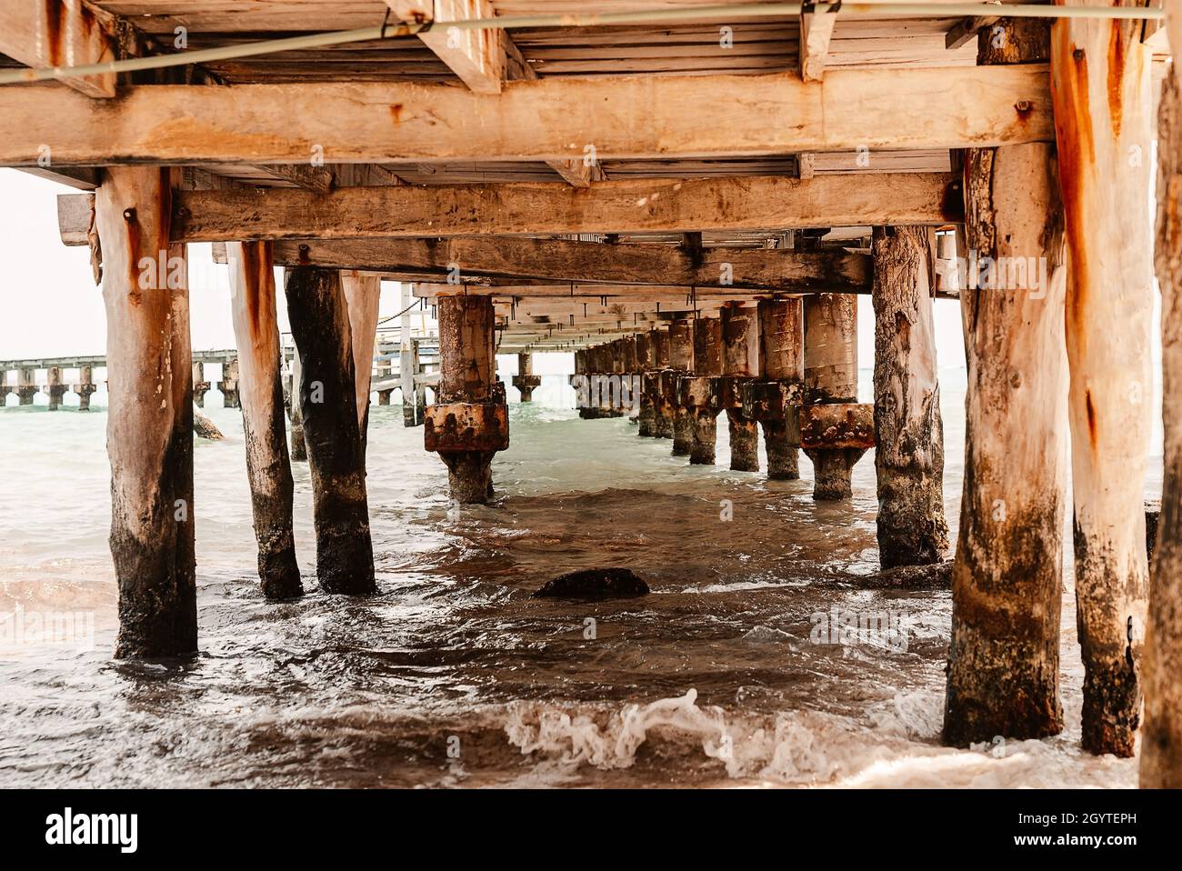 View of wooden under pier bridge over waves of sea Stock Photo - Alamy