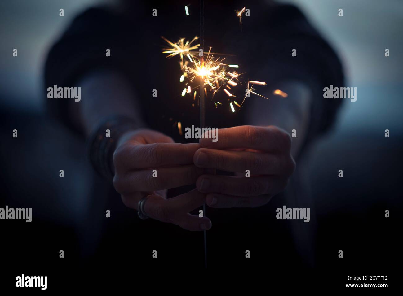 Human hands holding burning fire sparkle. Celebrating new year ...