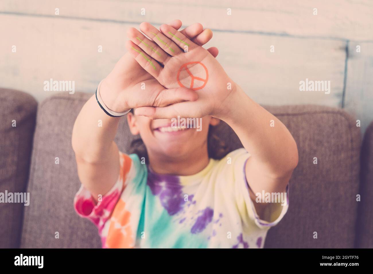 Teenage boy showing peace symbol drawn on palm of hand while relaxing ...