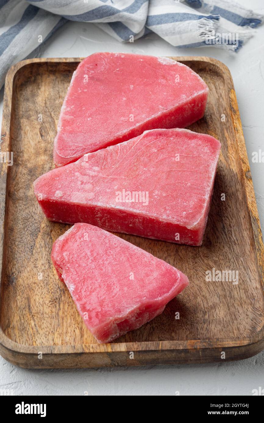 Raw frozen tuna fish fillet set, on wooden tray, on white stone ...