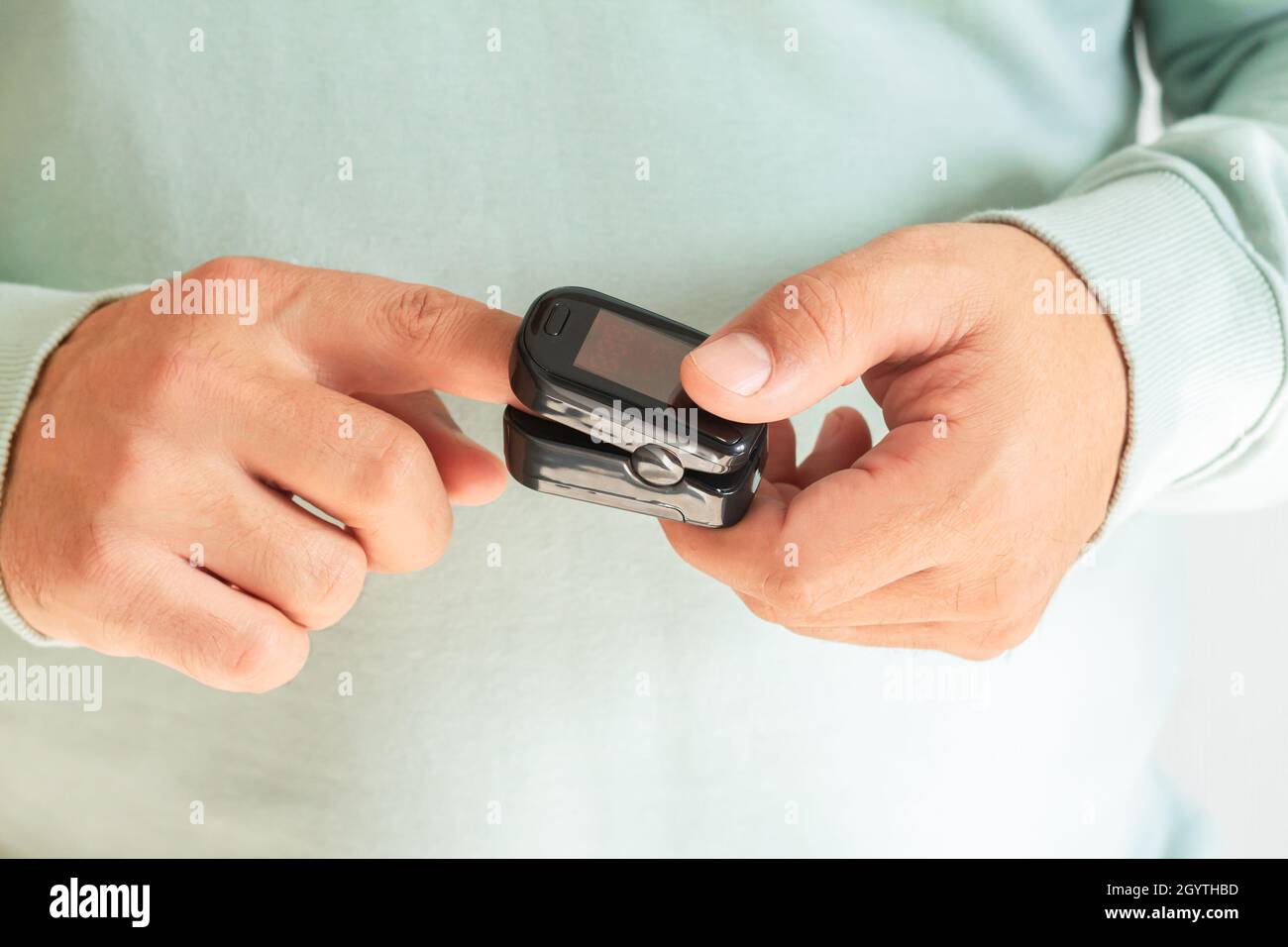 Man checking blood oxygen level with pulse oximeter at home. Health ...