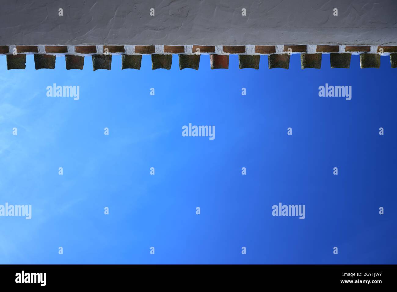 detail of a lower view of the eaves of a roof with blue sky in the ...