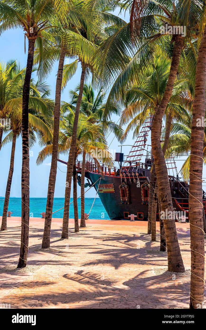 Coconut trees against pirate ship moored on harbor by sea Stock Photo ...