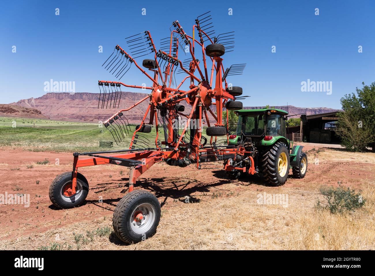 A rotary rake combines smaller rows of hay into one larger row to ...
