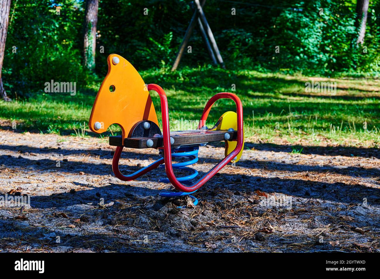 Children's playground with a swing toy in the foreground in a forest in ...