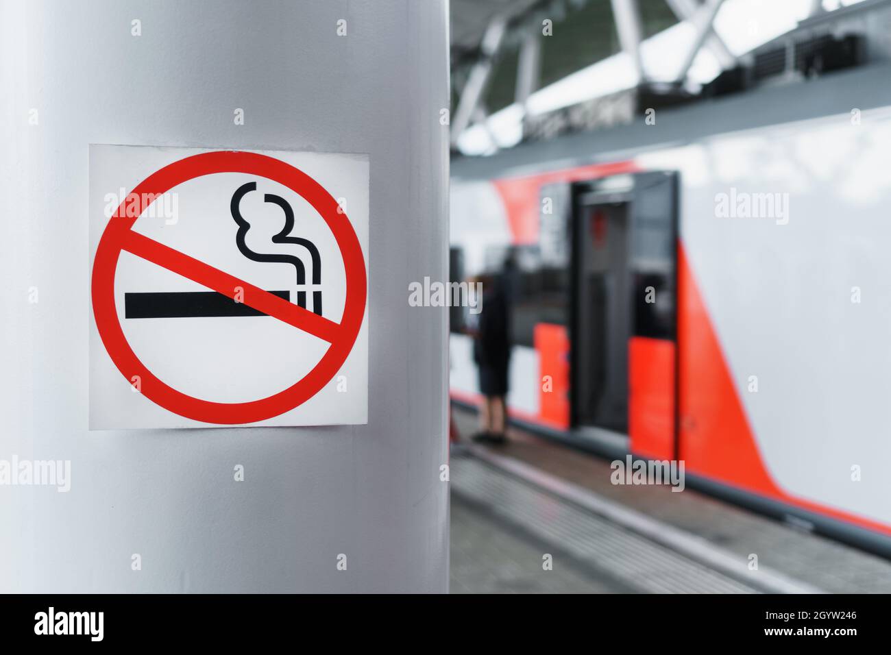 A sign prohibiting smoking on a pole near the railway platform. Smoking ...