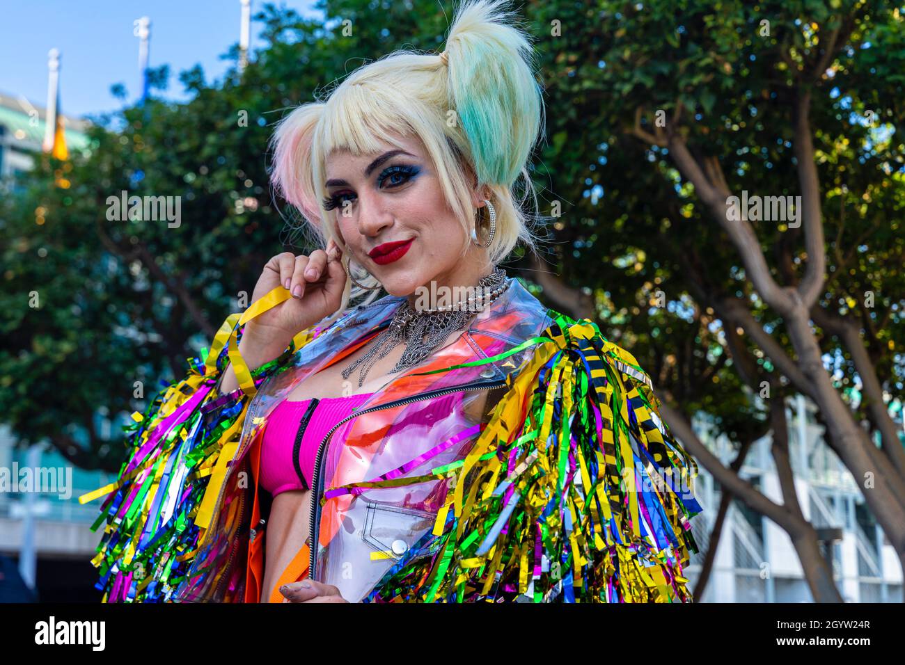 Attendee cosplayer portraying Harley Quinn in colorful costume at Comic ...