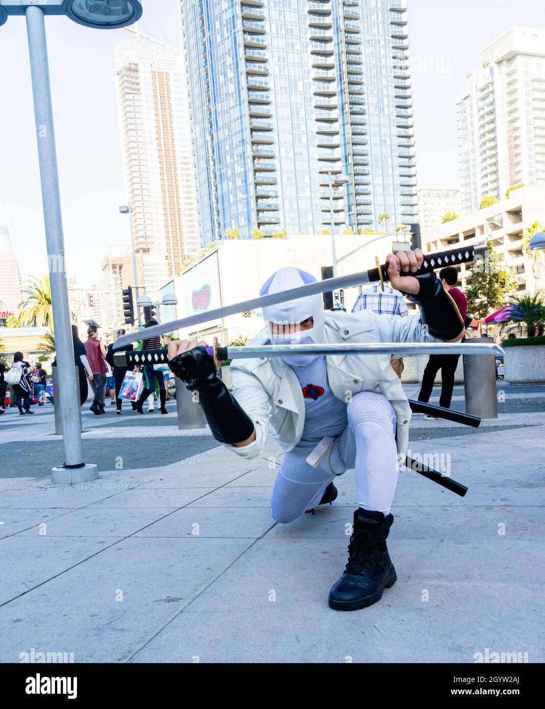 Attendee cosplayer portraying Japanese thug warrior ninja in white clothing with head cover and ...