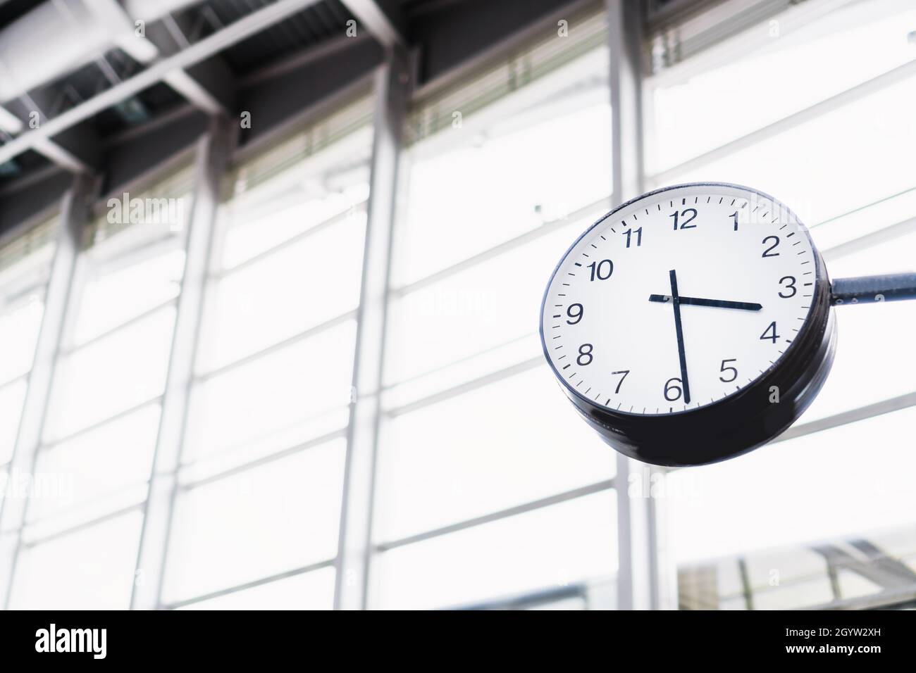 The arrow clock in the airport terminal on the background of windows ...
