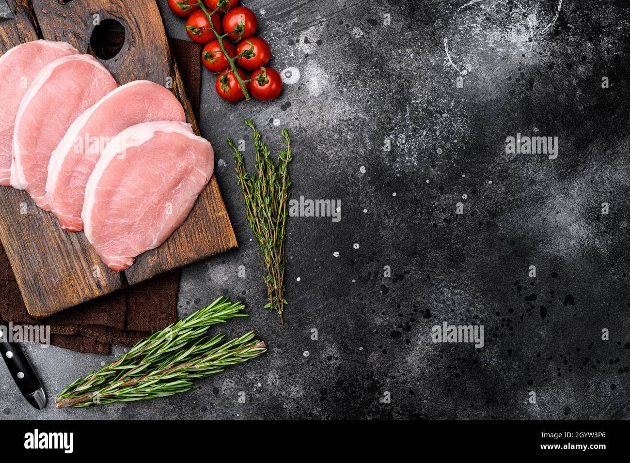Uncooked pork chop set, on black dark stone table background, top view ...
