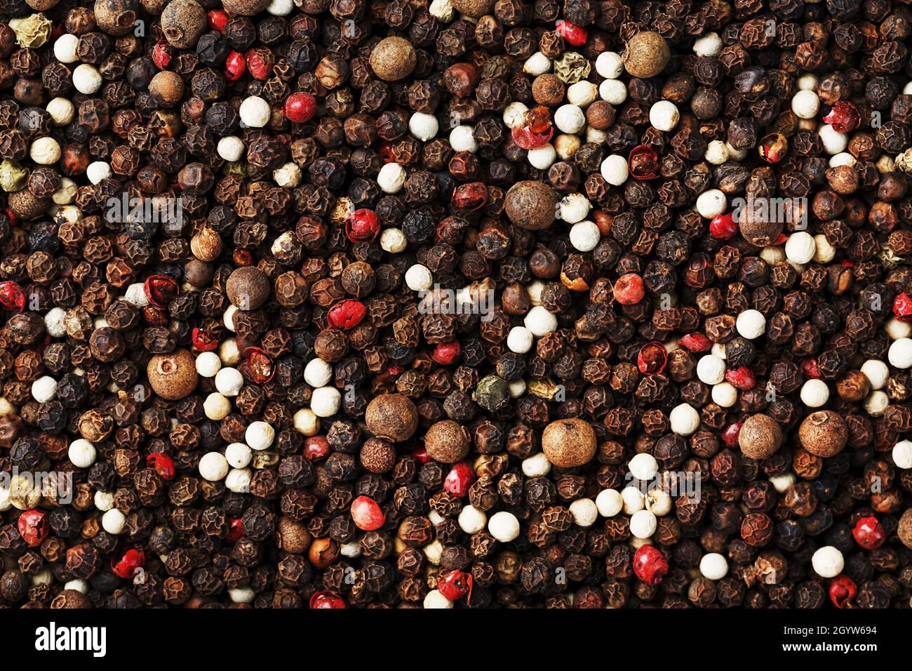 Pepper seeds close-up in full screen. Black, white, green and pink ...