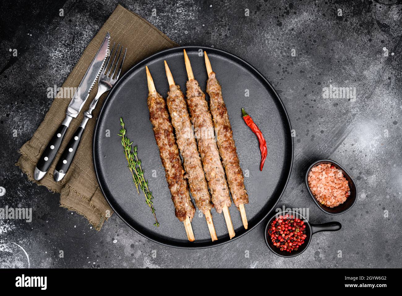 Grilled Lula kebab on skewers with spices, on plate, on black dark ...