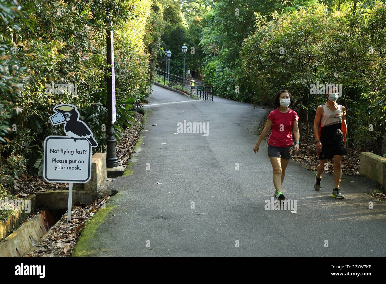 People wearing face masks as a preventive measure against the spread of covid-19 walk past a ...