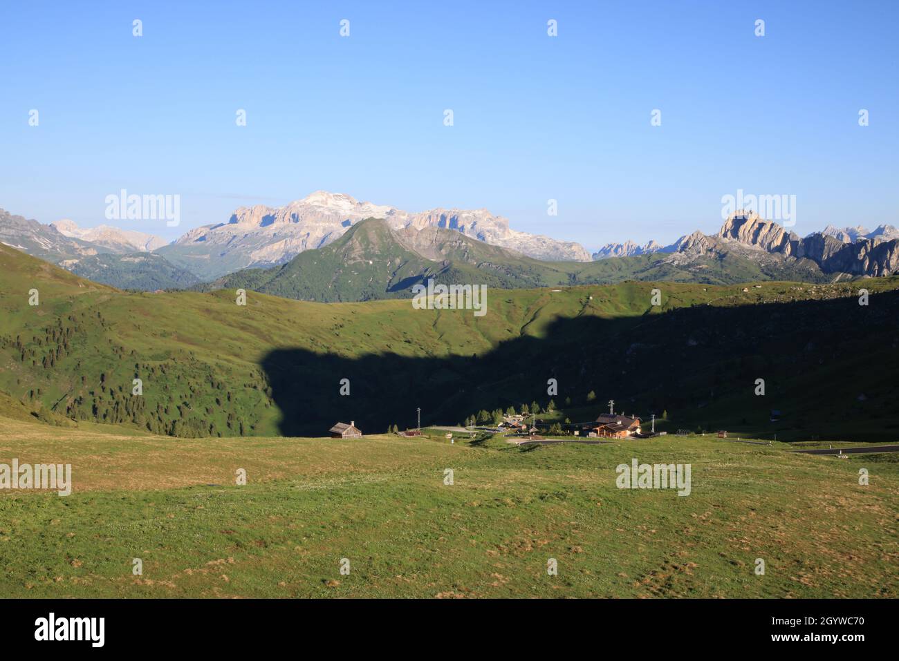 Beautiful scene of a green wide field with mountains in the background ...