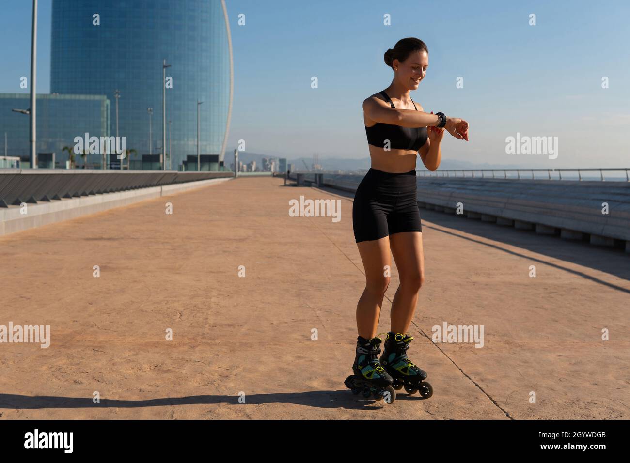 Full body glad sportswoman smiling and checking heart rate on smart ...