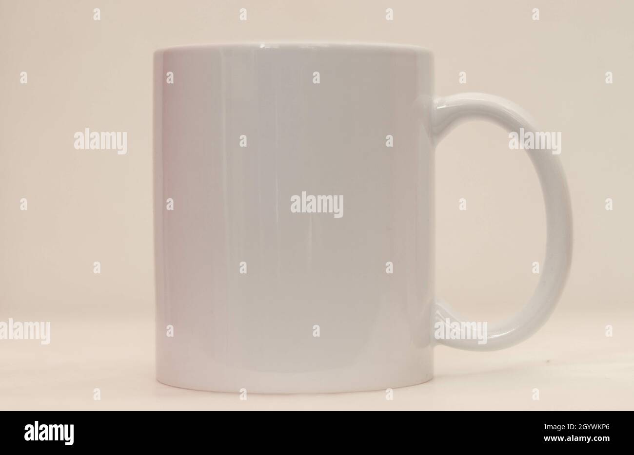 Classic white mug isolated in the light background Stock Photo - Alamy