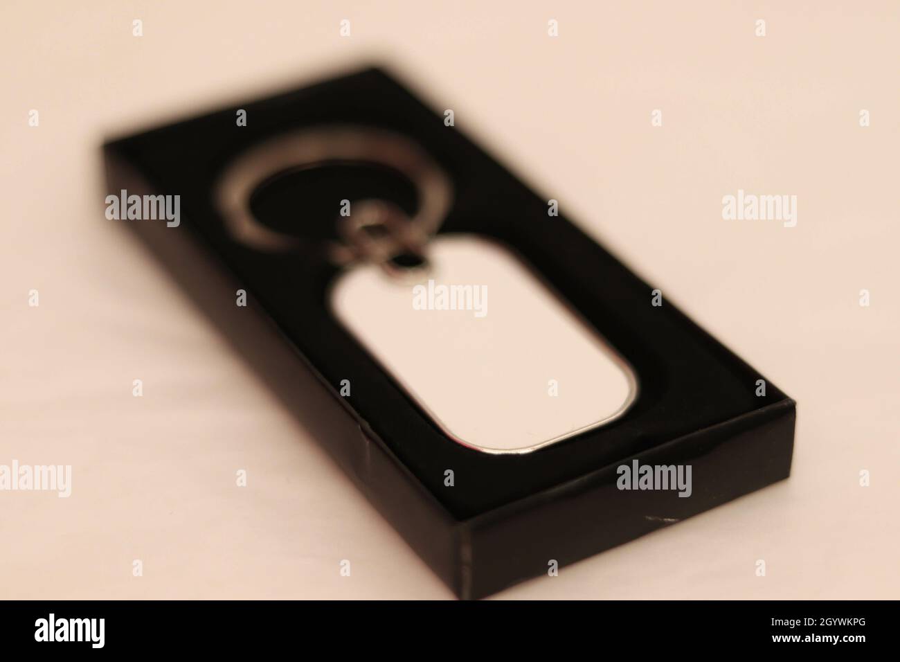 Rectangular metal keychain with a ring for a key in the box is isolated ...