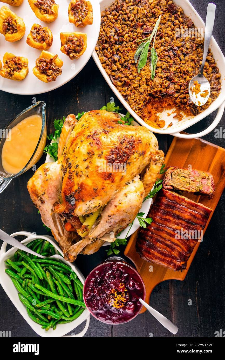 Thanksgiving Dinner on a Dark Wood Table: Roast turkey with gravy ...