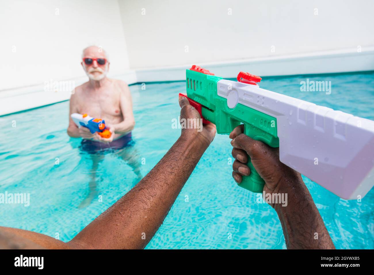 Happy seniors having party in the swimming pool - Elderly friends at a ...