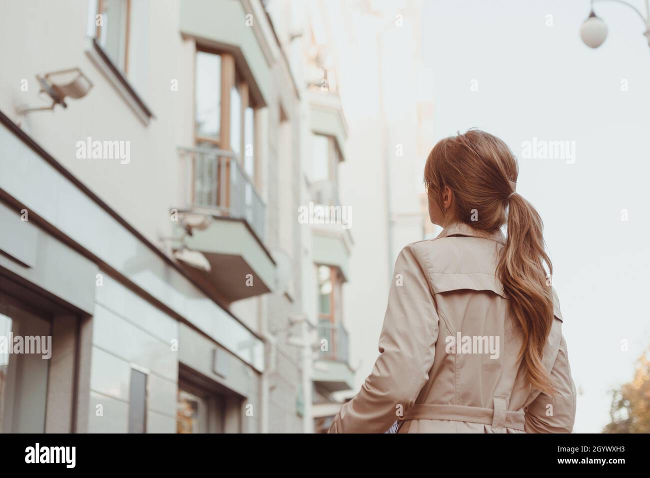 Back view of woman walking alone the city and looking at windows of ...