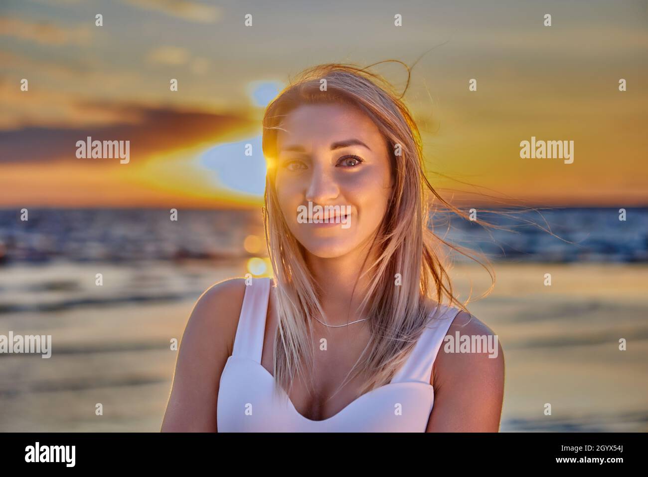 Portrait of smiling white woman on beach during sunset Stock Photo - Alamy