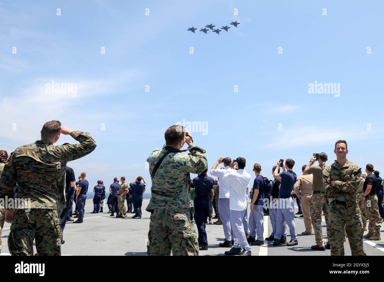US Marines and Royal Navy Sailors aboard HMS Queen Elizabeth look on as ...