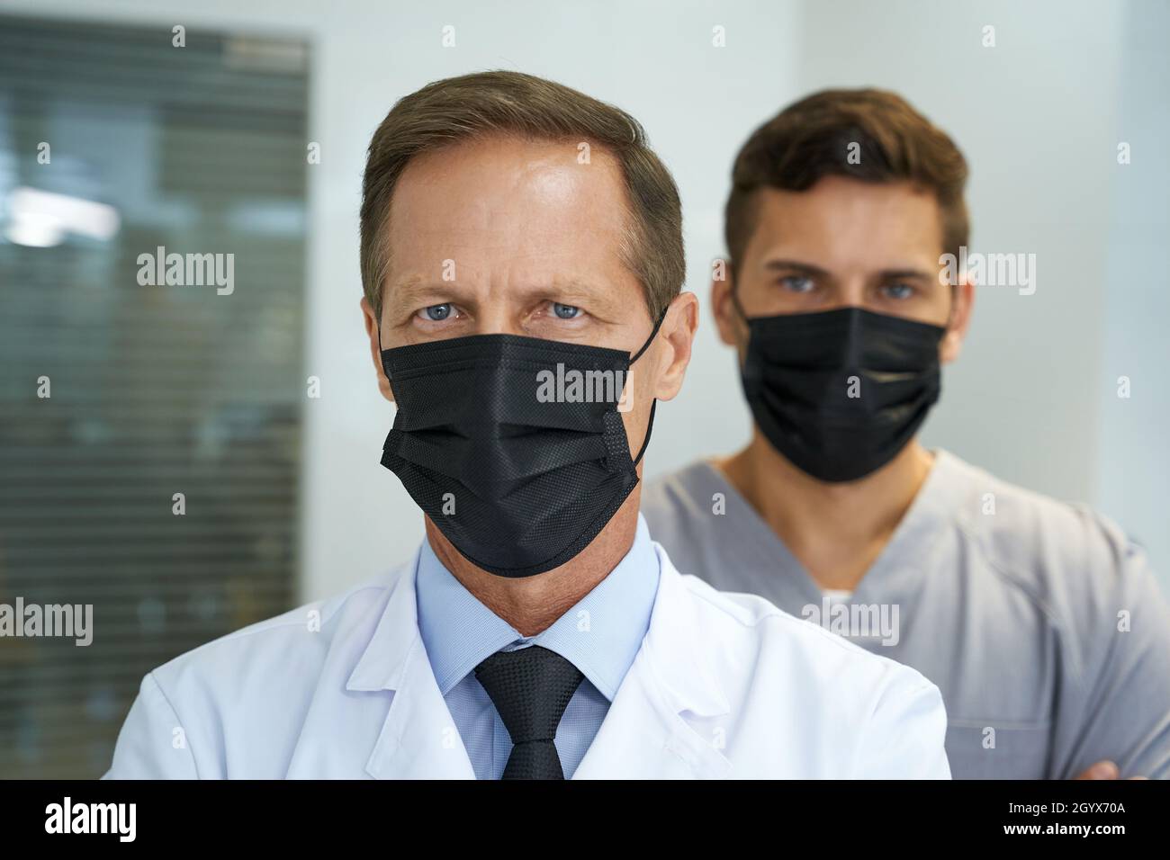 Two colleagues at medical clinic posing in masks Stock Photo - Alamy