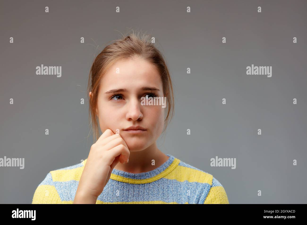 A frowning expression of a young woman. Think hard about something but ...