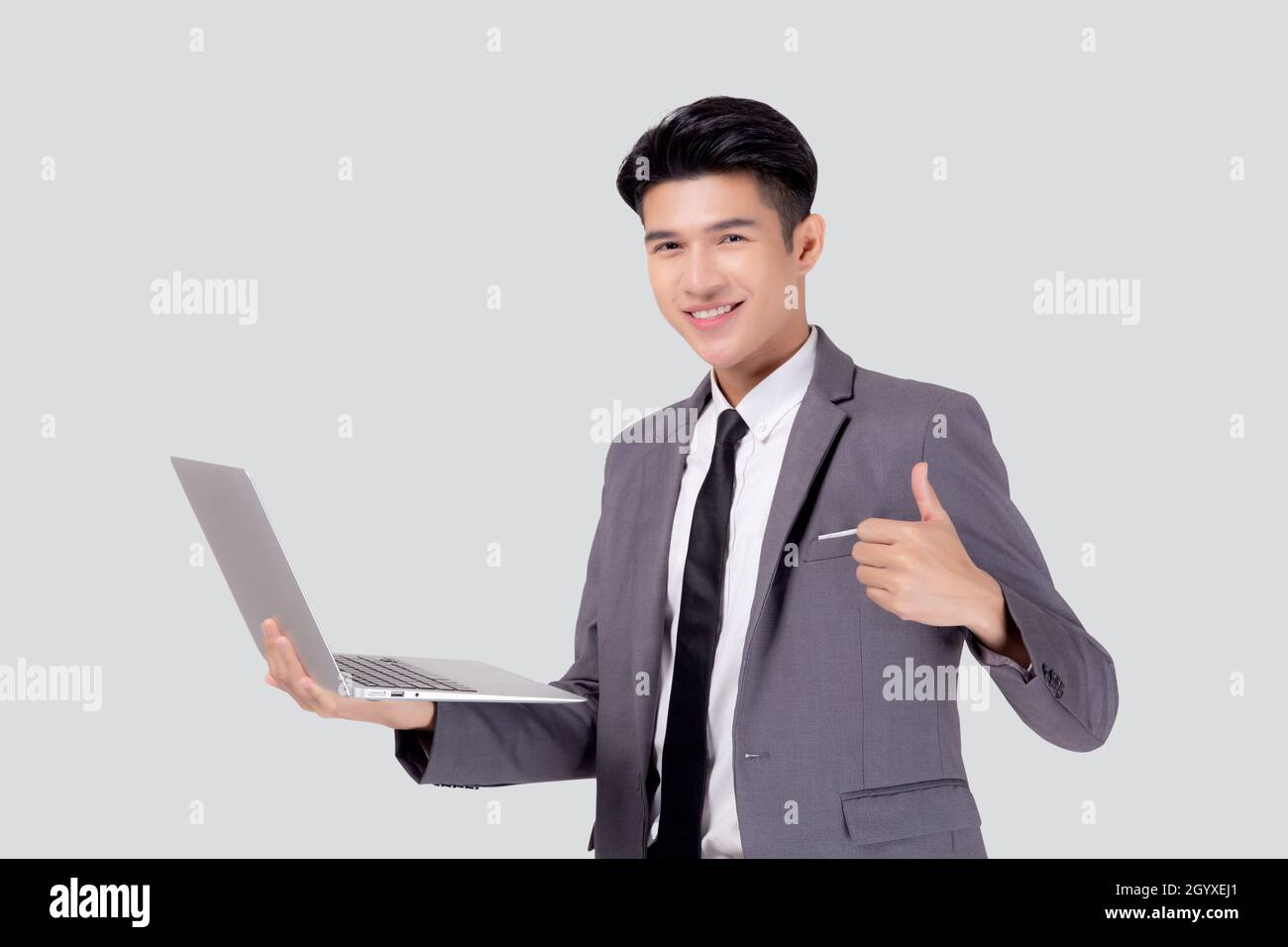 Young asian business man standing work on laptop computer to internet ...