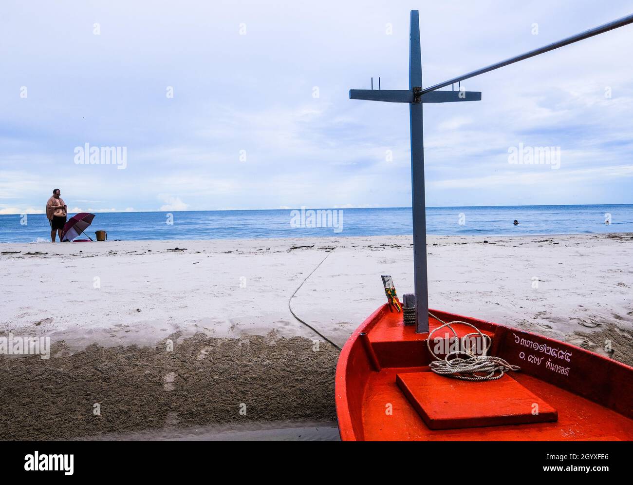 A solitary male bather in the distance looks around the beach at Hua ...