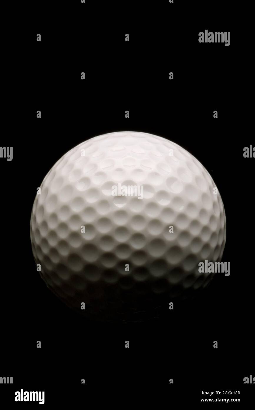 Golf ball with dramatic lighting on black background Stock Photo - Alamy