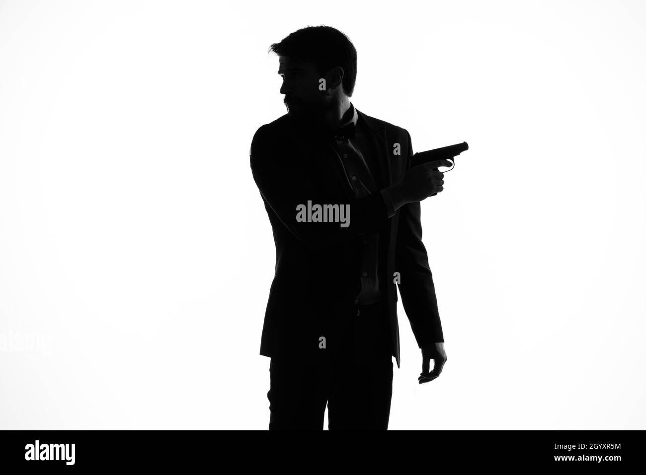 The man in a suit with a pistol in hand crime hand gesture light ...