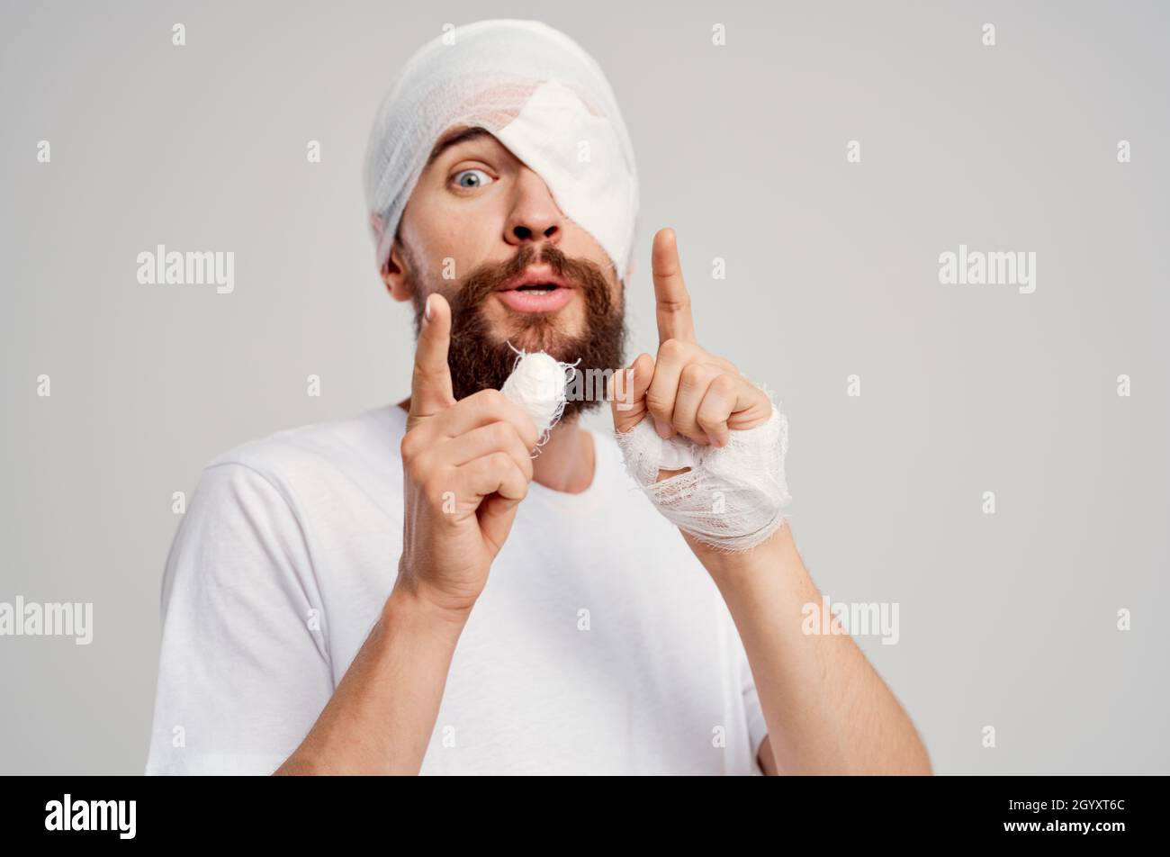 bearded man with a bandaged head and an eye blood light background ...
