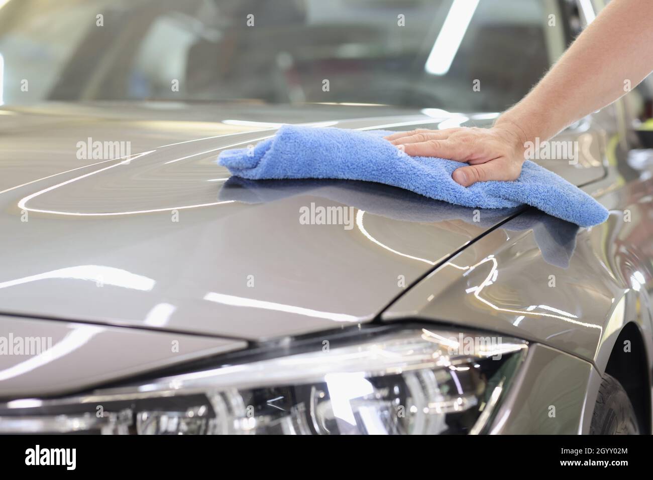 Hood of gray car is wiped with microfiber at car wash Stock Photo - Alamy