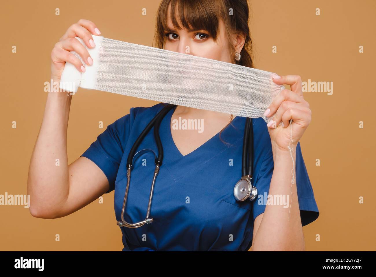 a female doctor in a white coat holds twisted gauze bandages for ...