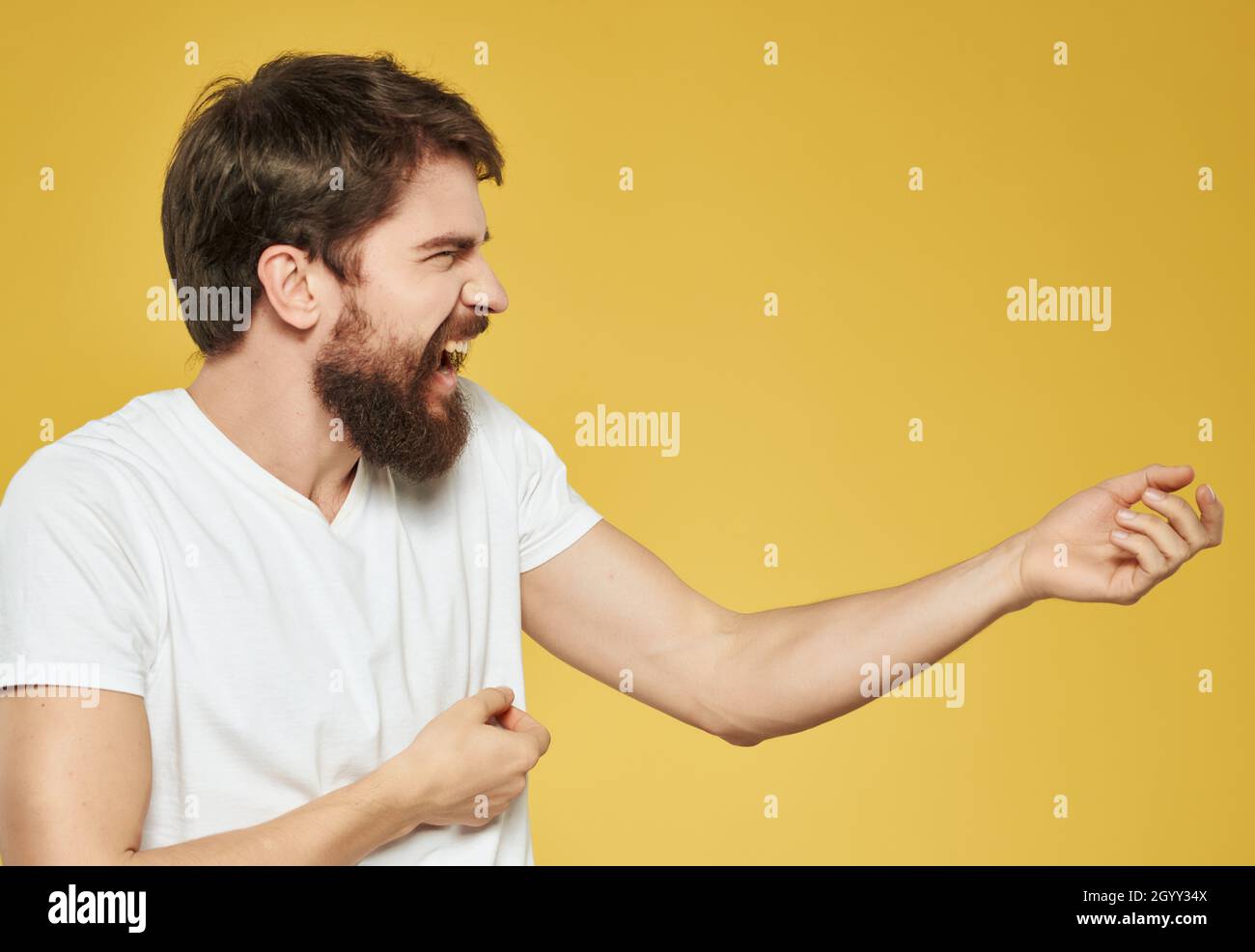 Man in a white t-shirt hand gestures anger yellow background Stock ...