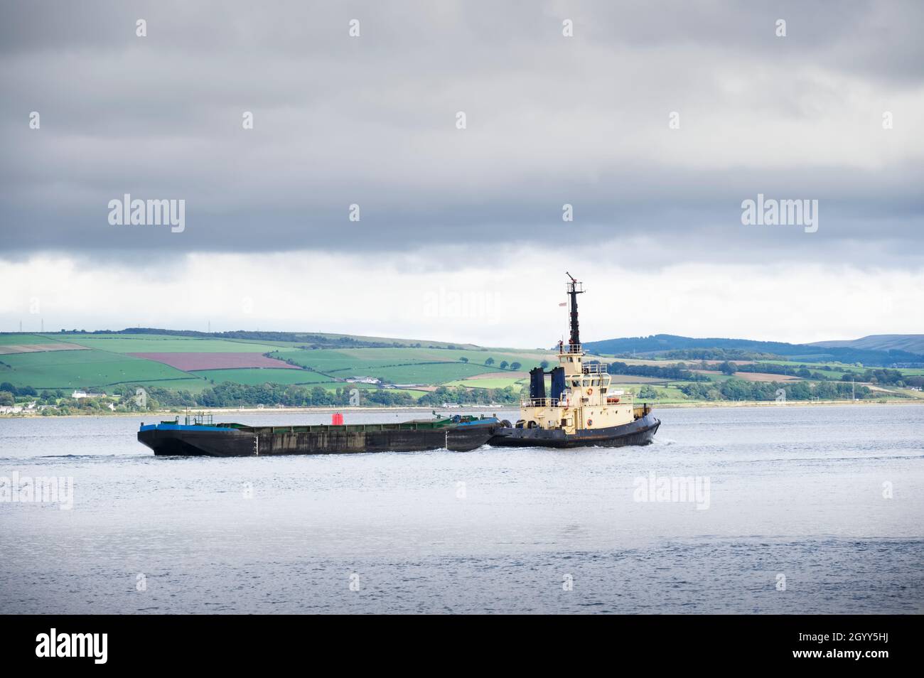 Tugboat transporting floating storage container platform in sea Stock ...