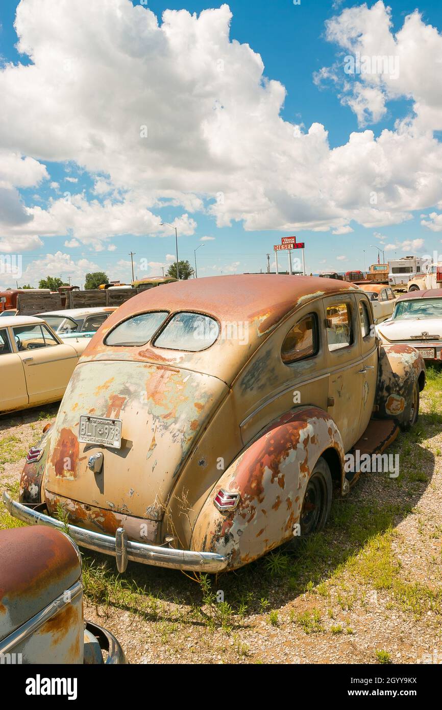 A rusted vintage ford deluxe fordor car parked on grassy ground ...