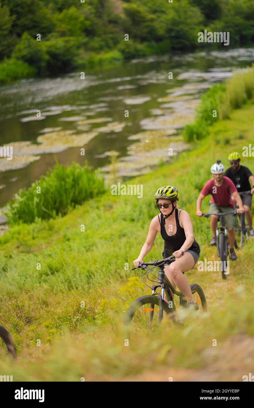 Portrait of beautiful girl trying to follow her group while ridin gher ...