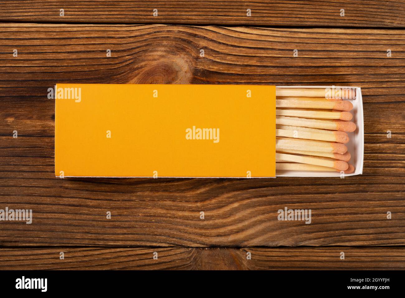 top view orange color matchbox with orange match sticks on a wood table ...