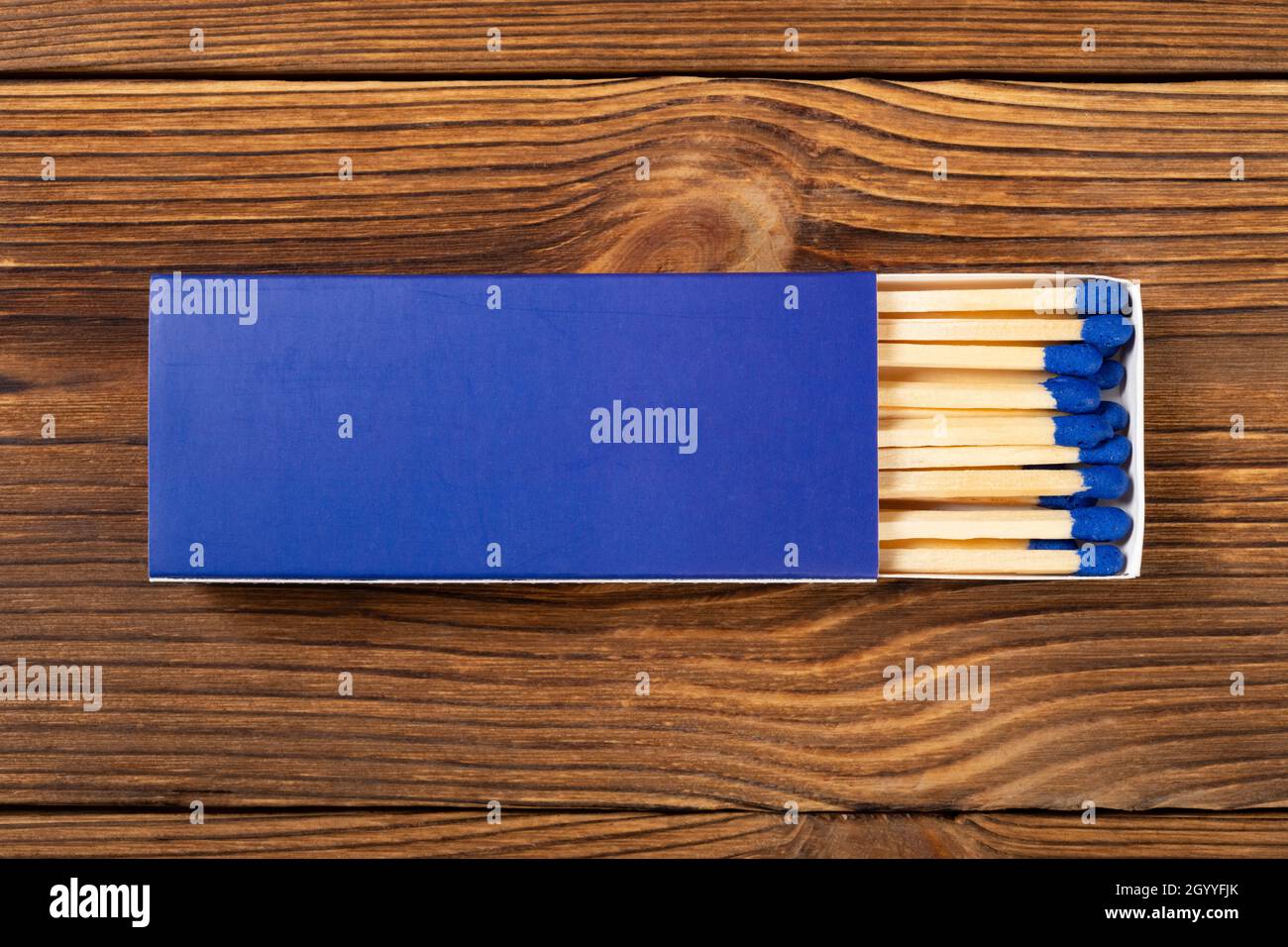 top view navy blue color matchbox with navy blue match sticks on a wood ...