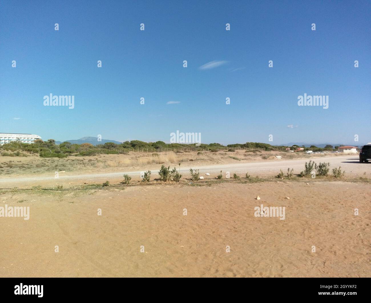 Sandy beach with mountains and hotel in the background in Turkey Stock ...