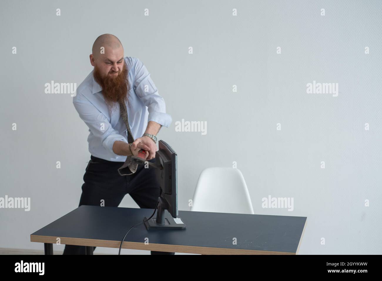 Stressed crazy businessman smashing his computer in office using ax ...