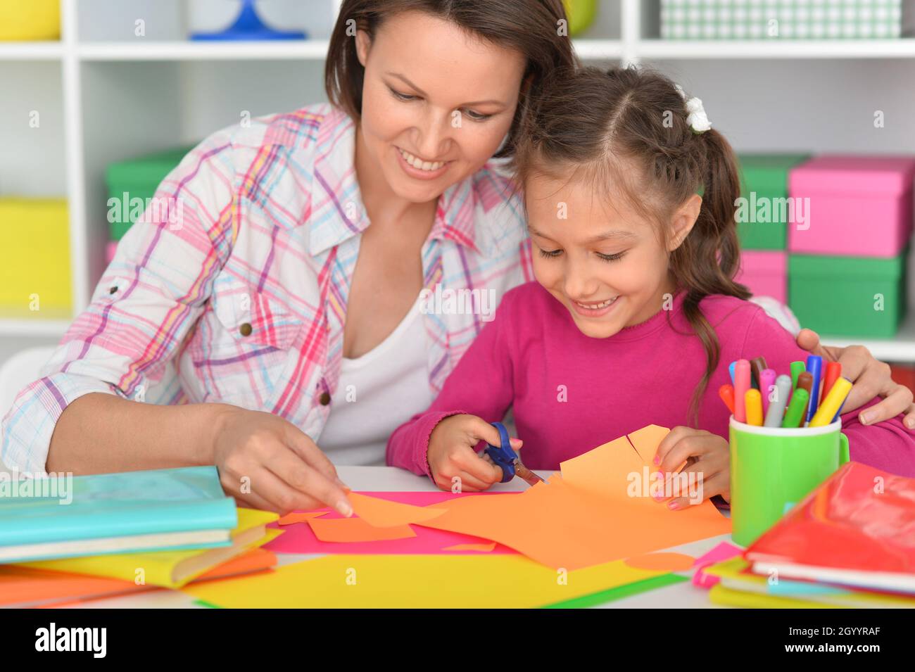 Mother teaches her cute daughter to do craft items Stock Photo - Alamy