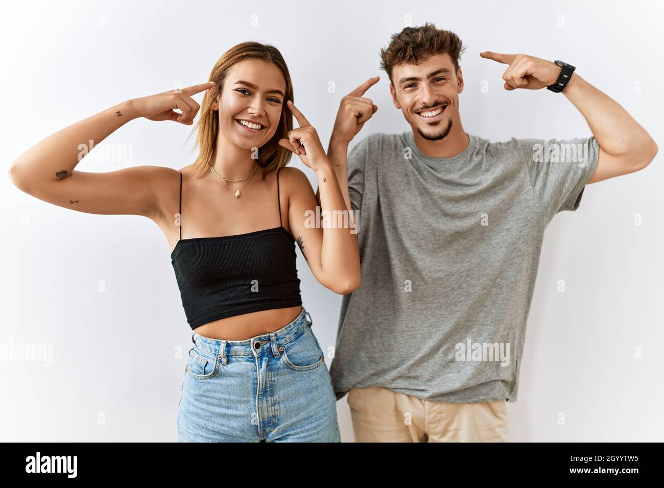 Young beautiful couple standing together over isolated background ...