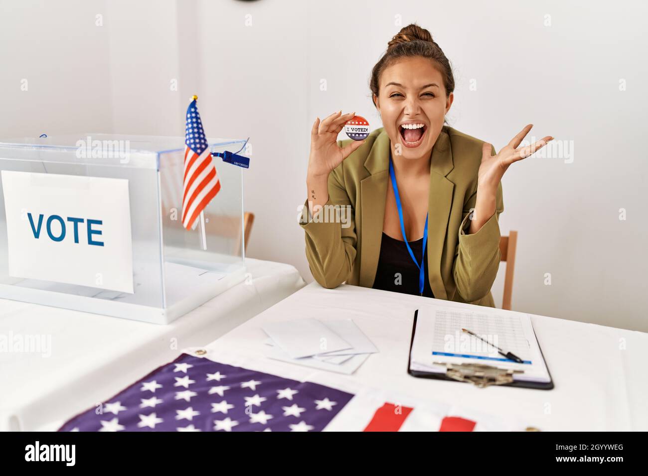 Beautiful hispanic woman at political campaign by voting ballot ...