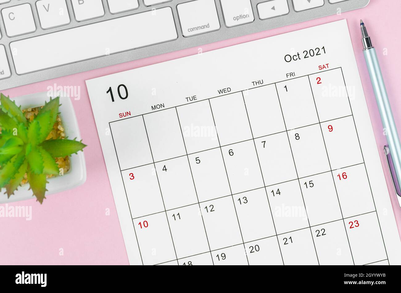 October 2021 calendar sheet with keyboard computer on pink background ...