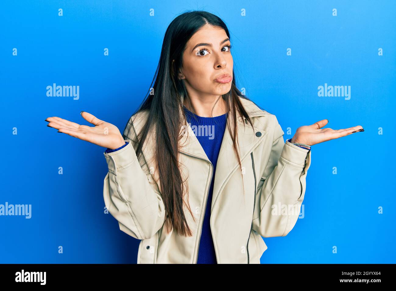 Young hispanic woman wearing casual leather jacket clueless and ...