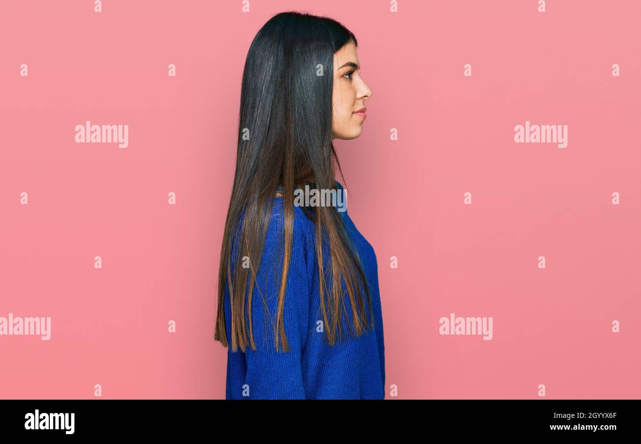 Young hispanic woman wearing casual clothes looking to side, relax ...